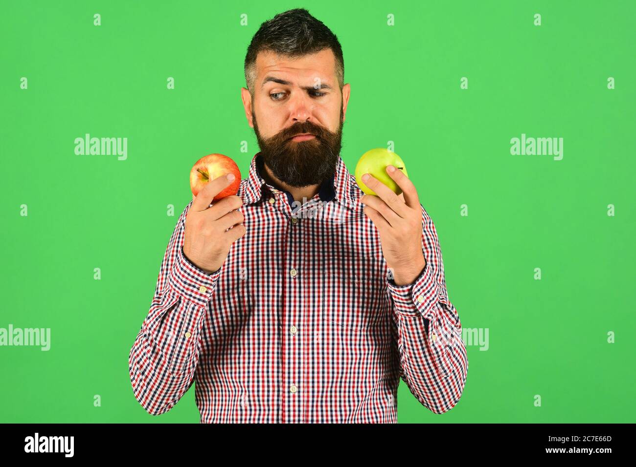 Gardening and product choice concept. Man with beard holds red and ...