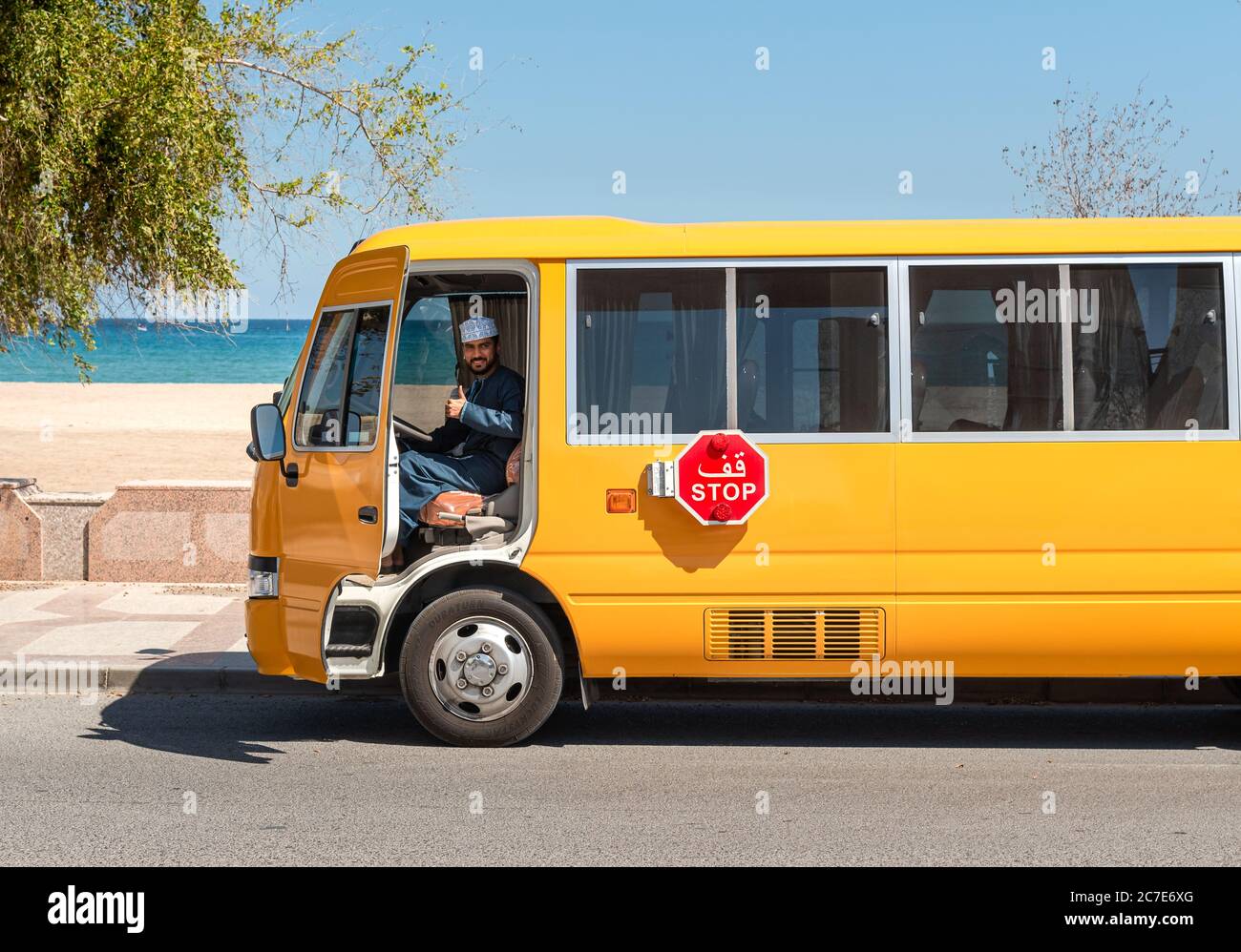 Sur, Oman - February 15, 2020: Yellow bus with driver in traditional ...