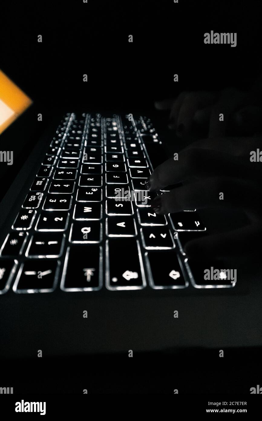 Vertical shot of a person typing with a keyboard at night - perfect for ...