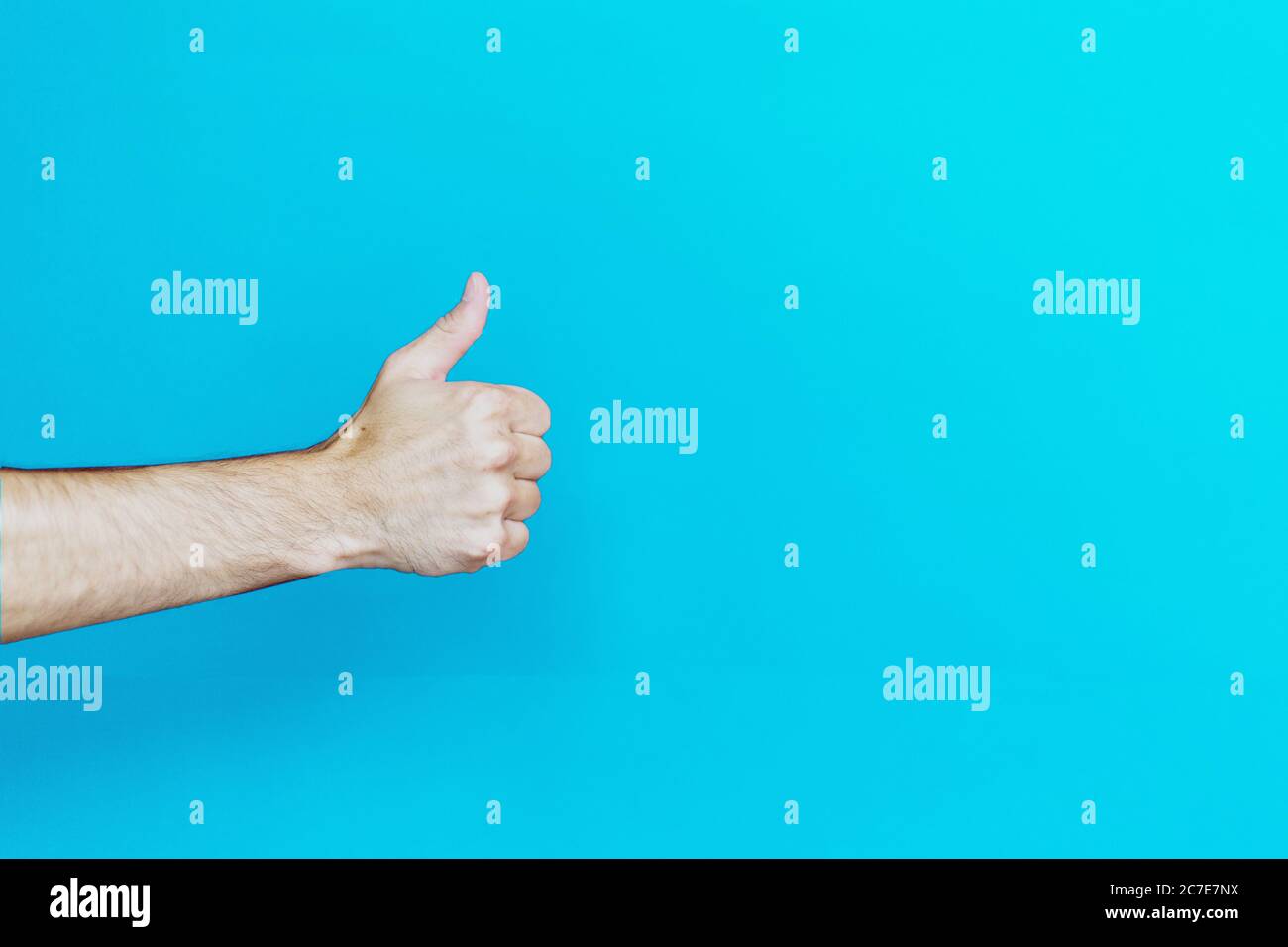 Person's hand showing a thumbs up on a light blue background - great ...