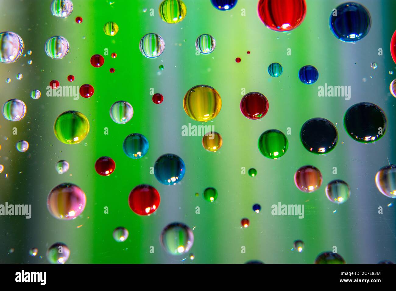 Abstract colorful water drops in green background Stock Photo - Alamy