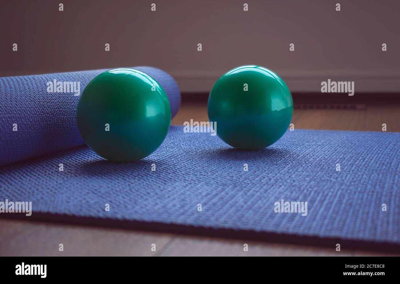 Yoga mat and balls with pastel background Stock Photo - Alamy