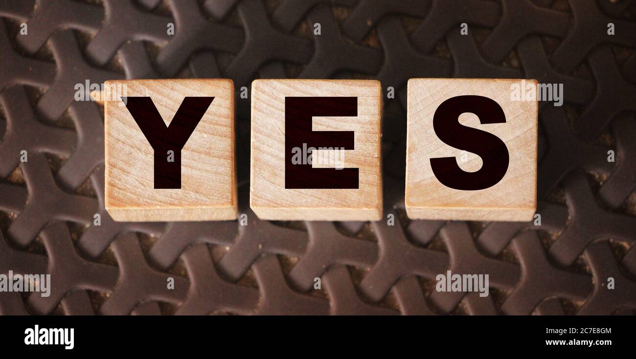 The inscription YES on wooden blocks on dark background Stock Photo - Alamy
