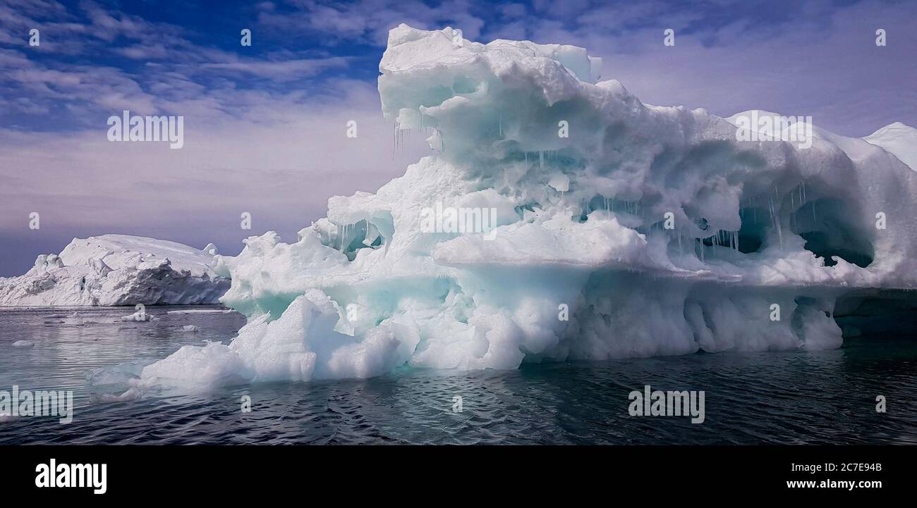 Dramatic iceberg covered in icicles floating in Greenlan fjord Stock ...