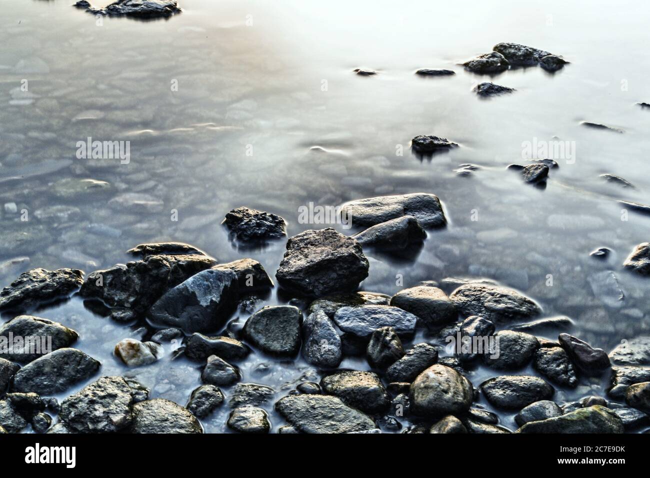 Horizontal shot of the beautiful sea with a lot of rocks and the ...