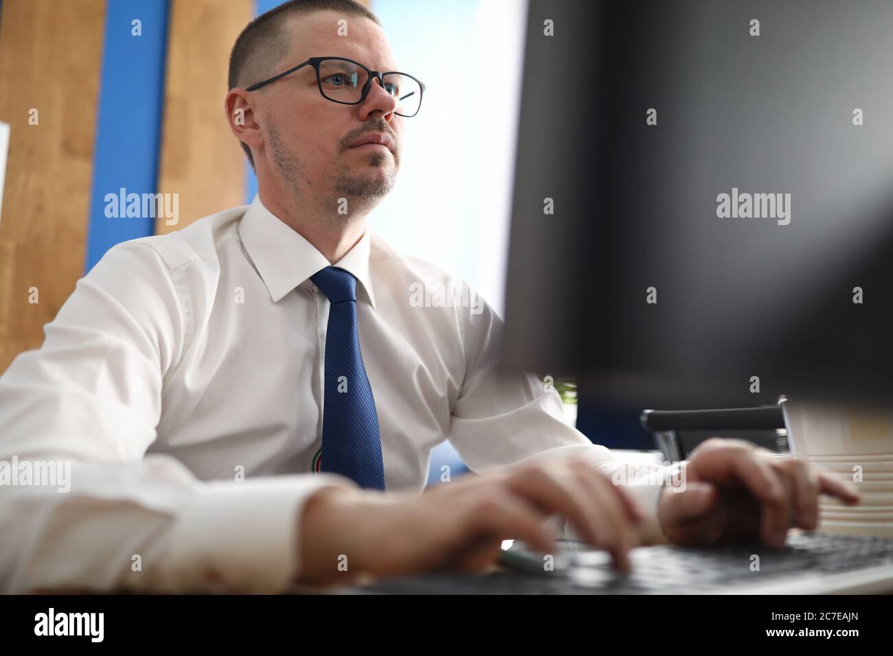 Confident and pensive man working with computer at workplace Stock ...