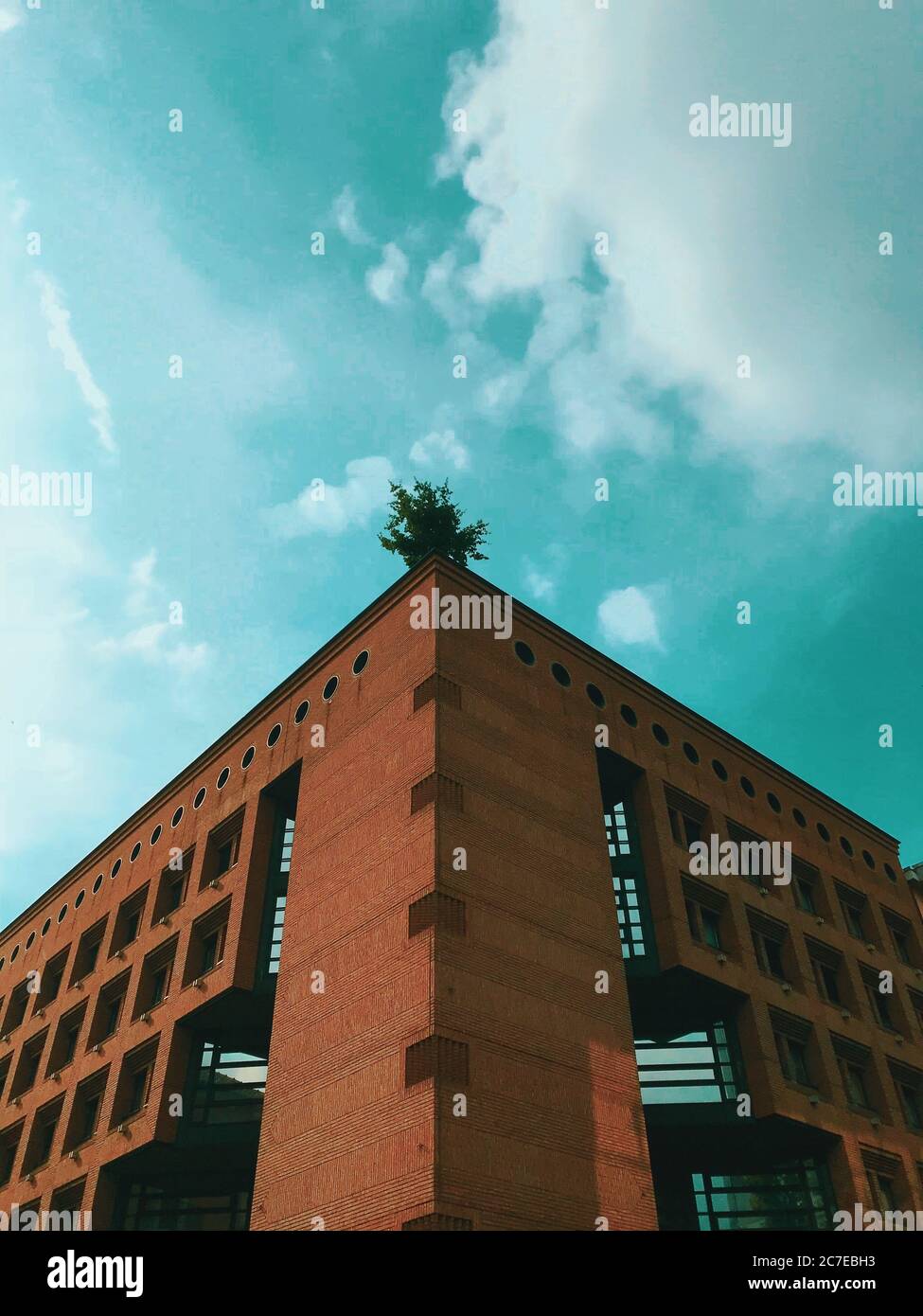 Vertical low angle shot of a concrete building under the beautiful cloudy sky Stock Photo - Alamy