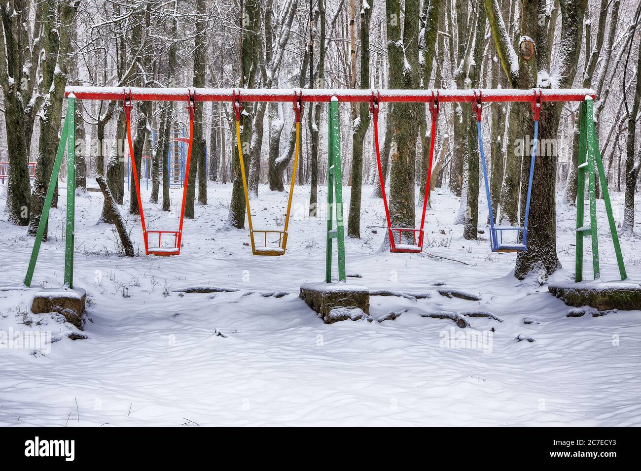 Empty swing in winter time with snow. Children's swing under a thick ...