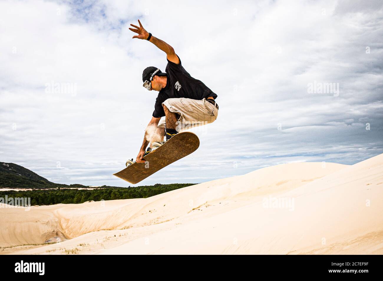 Man sandboarding on the dunes of Rio Vermelho State Park. Florianopolis ...