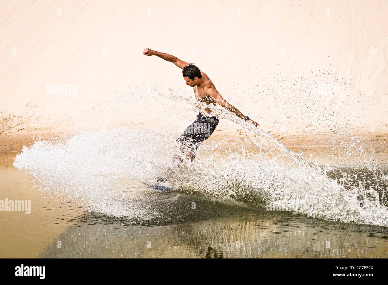 Man sliding on the water with a sandboard at Joaquina Beach ...
