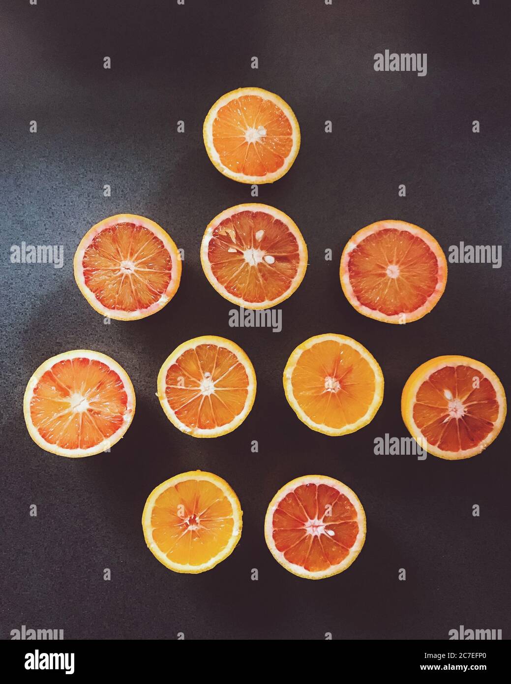 Vertical high angle shot of sliced oranges on a black surface - great ...