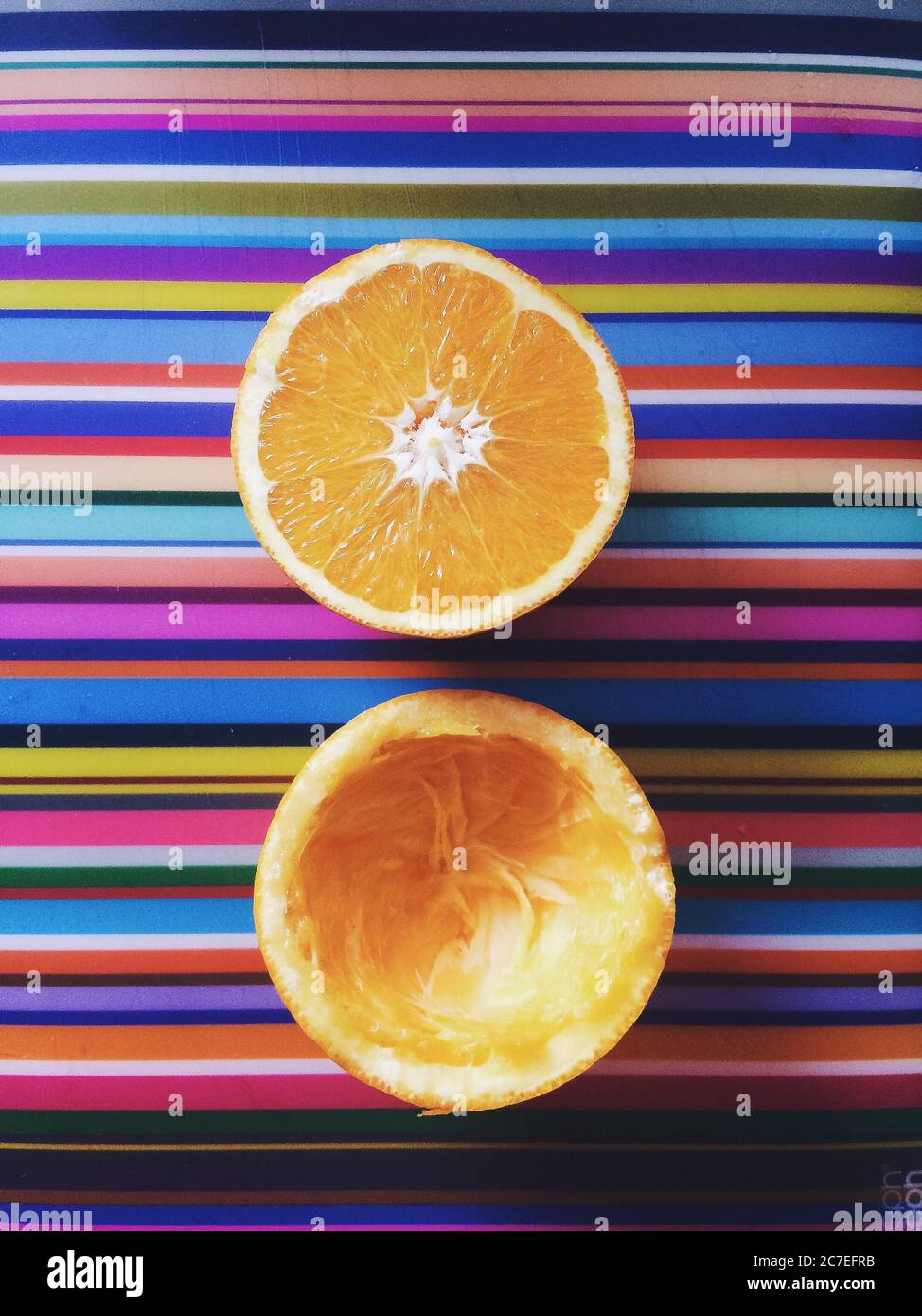 High angle vertical shot of a sliced orange and an empty orange peel on ...