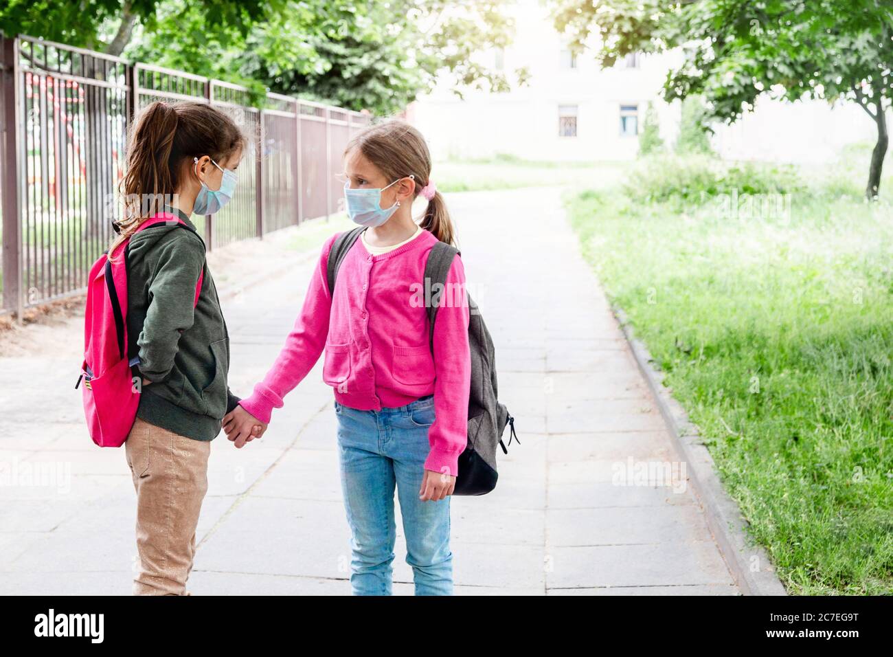 Two schoolgirls wearing masks and going back to school during covid-19 ... Two schoolgirls wearing masks and going back to school during covid-19 ...