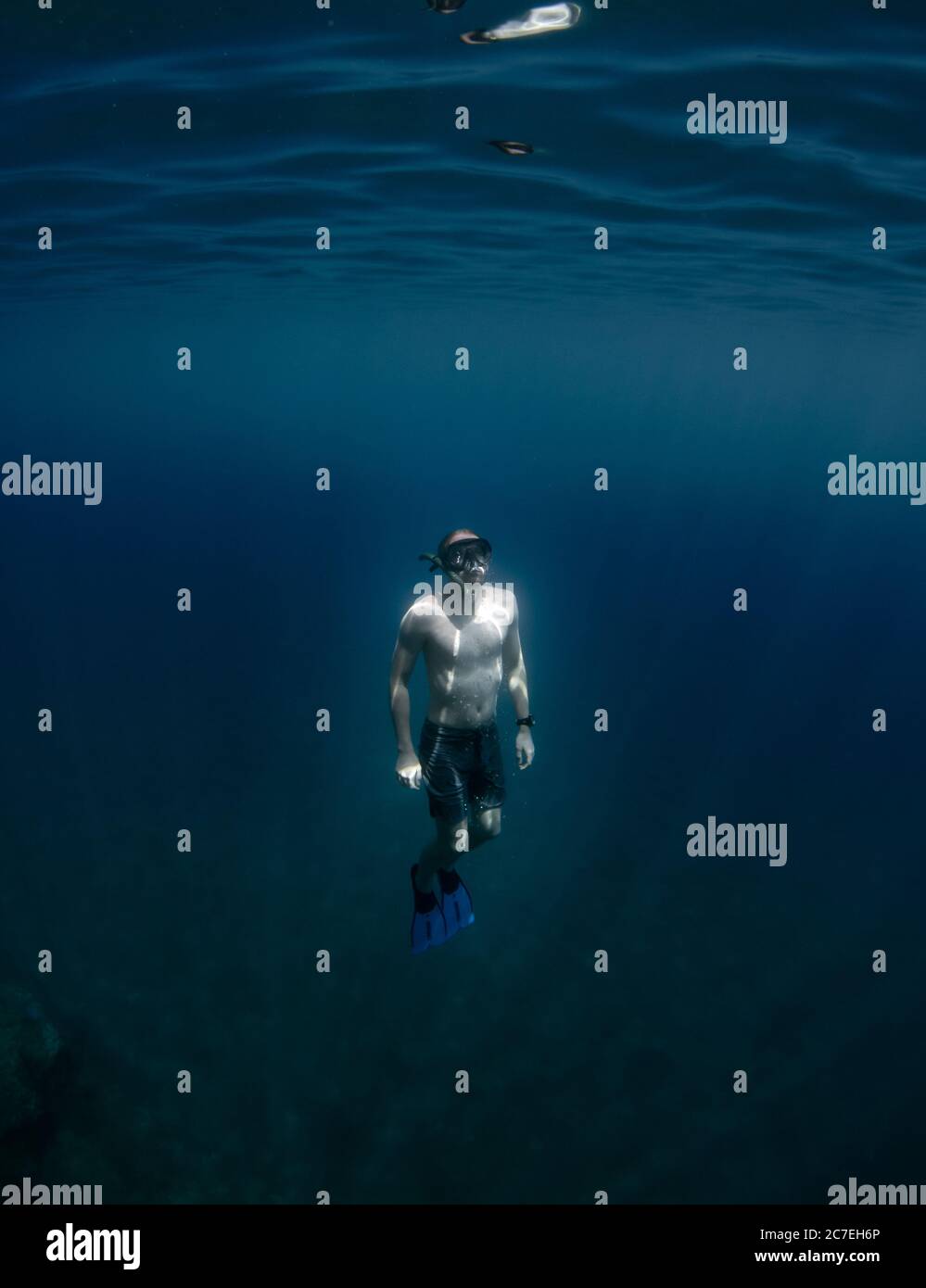 Young man swimming and freediving in the blue clear mediterranean sea ...