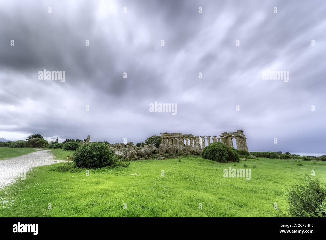 Wide shot of isolated abandoned building ruins in a green field under ...