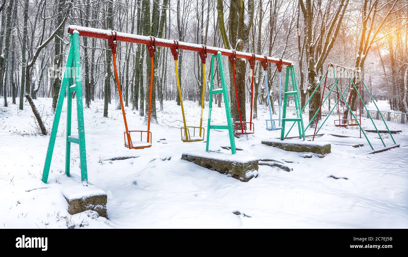 Empty swing in winter time with snow. Children's swing under a thick ...