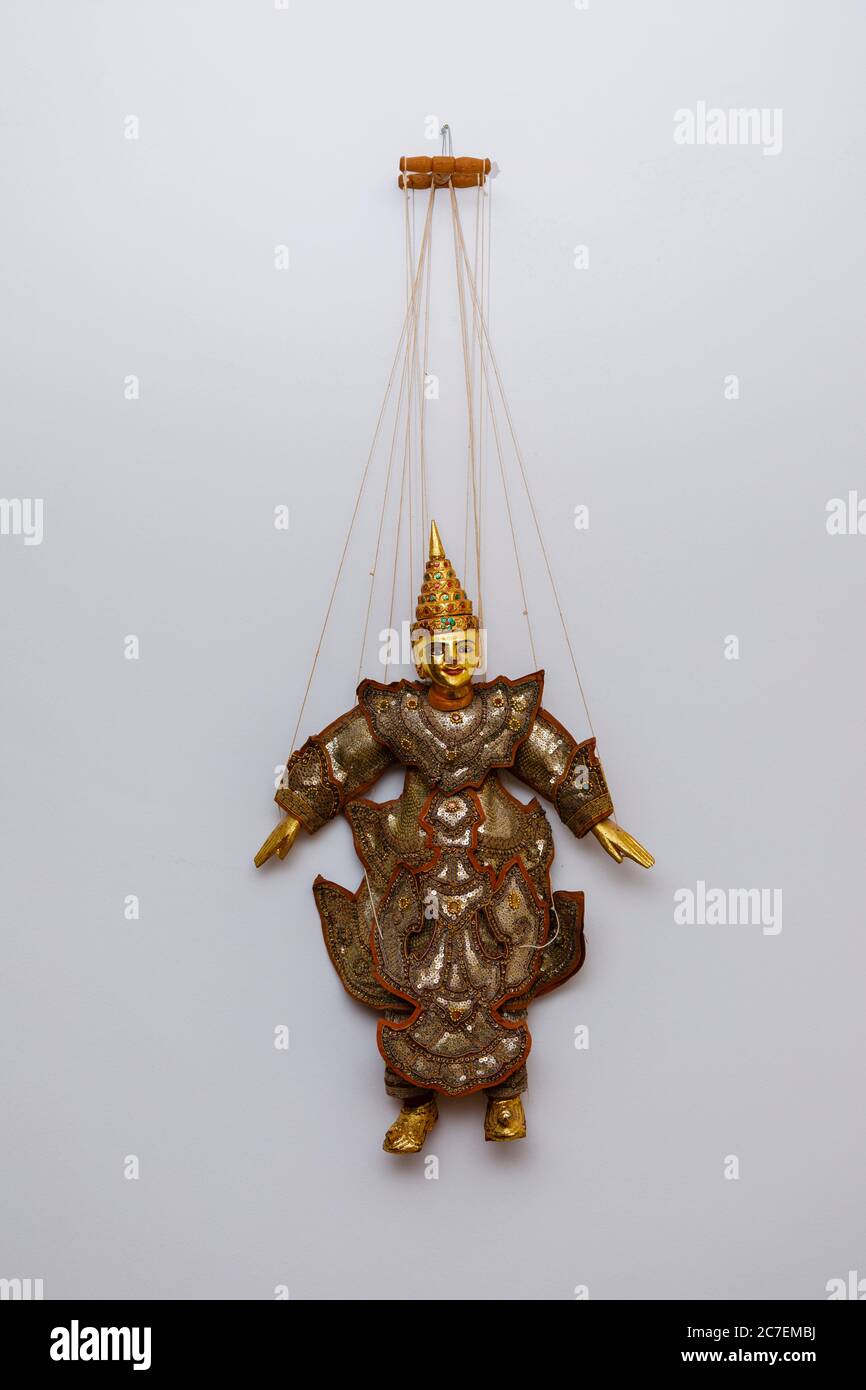 A traditional sequinned golden king figure wooden puppet on strings, a ...