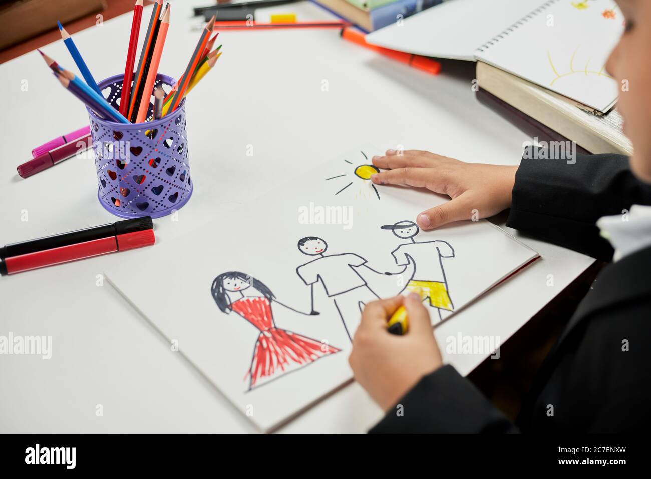Family therapy. Schoolboy drawing family. Painting with colored marker ...