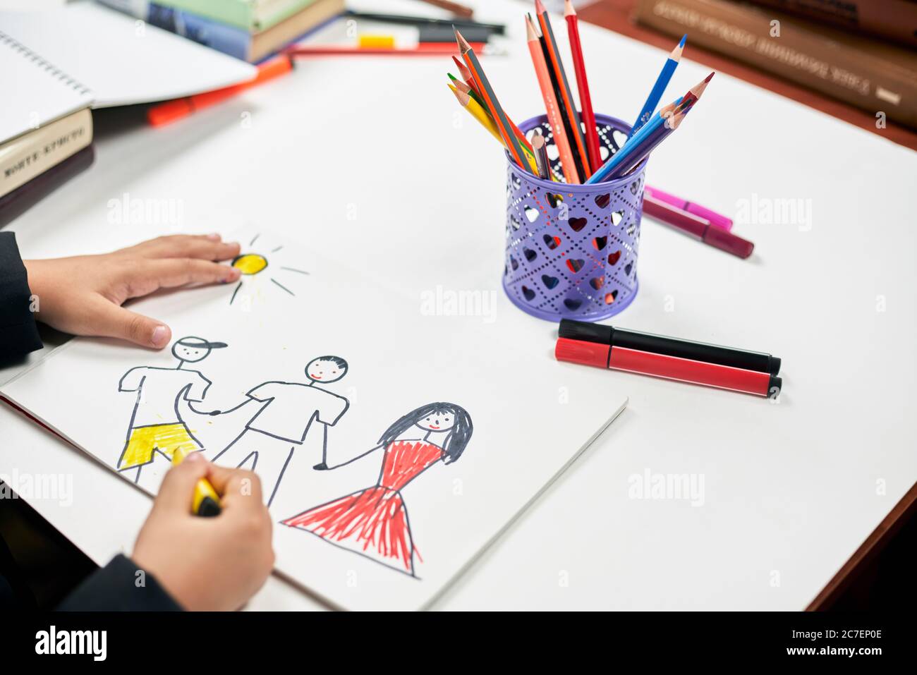 Family therapy. Schoolboy drawing family. Painting with colored marker ...