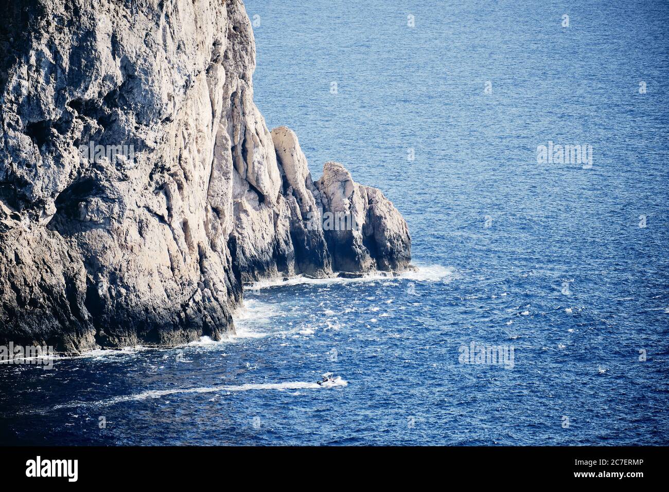 High angle shot of a boat sailing near the cliff at daytime Stock Photo ...