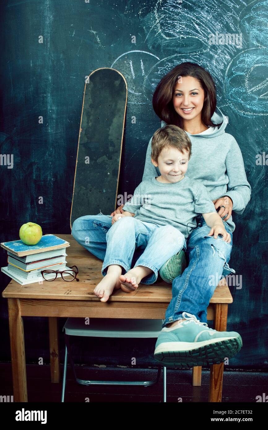 little cute boy in glasses with young real teacher, classroom studying ...
