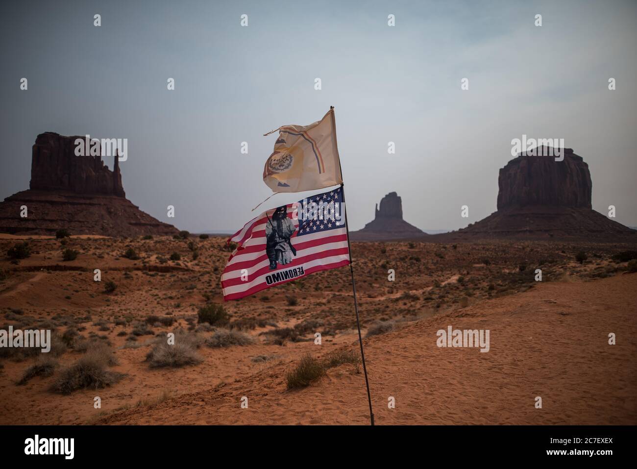 Horizontal shot of flag of US with a Geronimo print in front of rock ...
