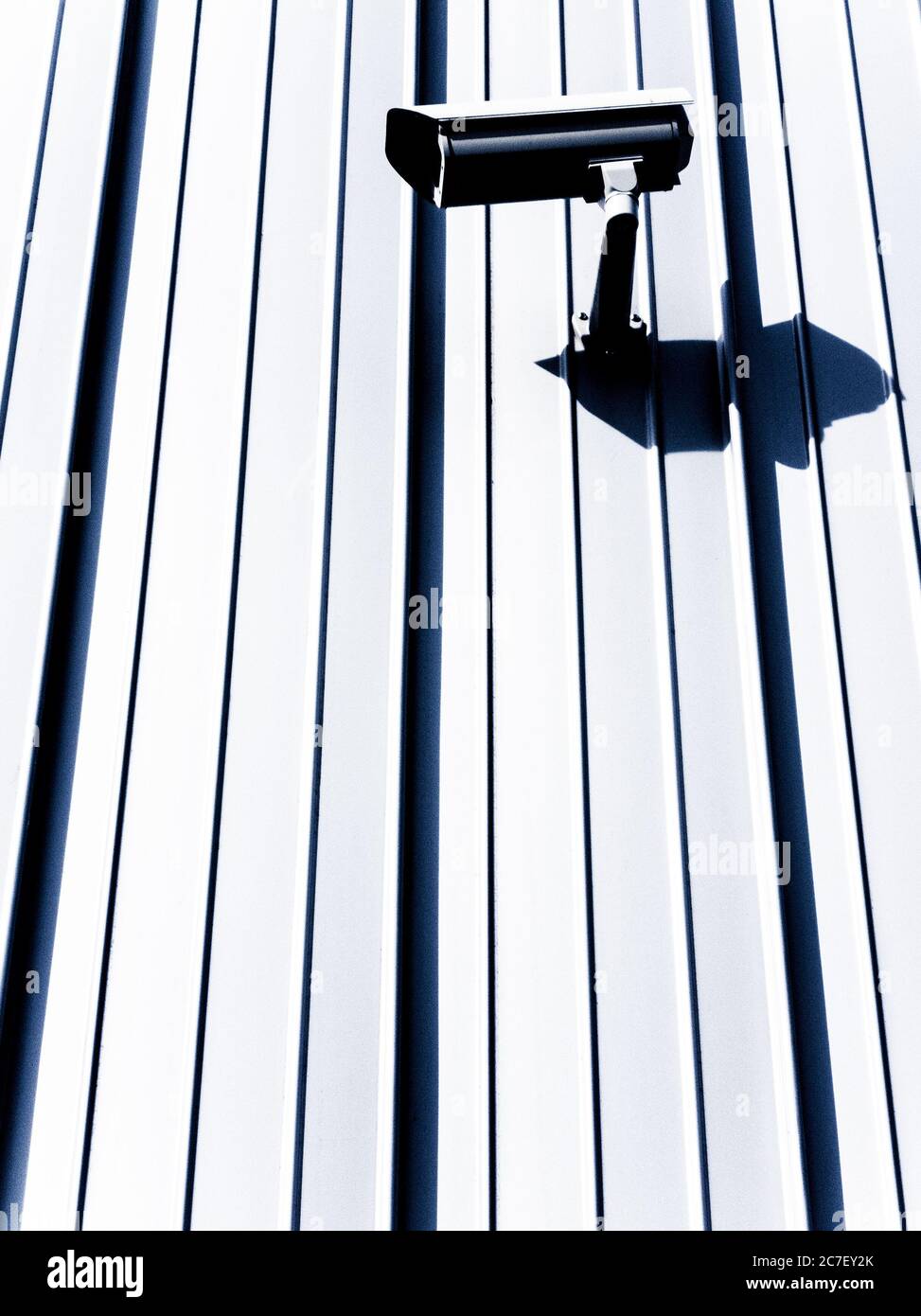 Vertical shot of a security camera on a white surface during daytime ...