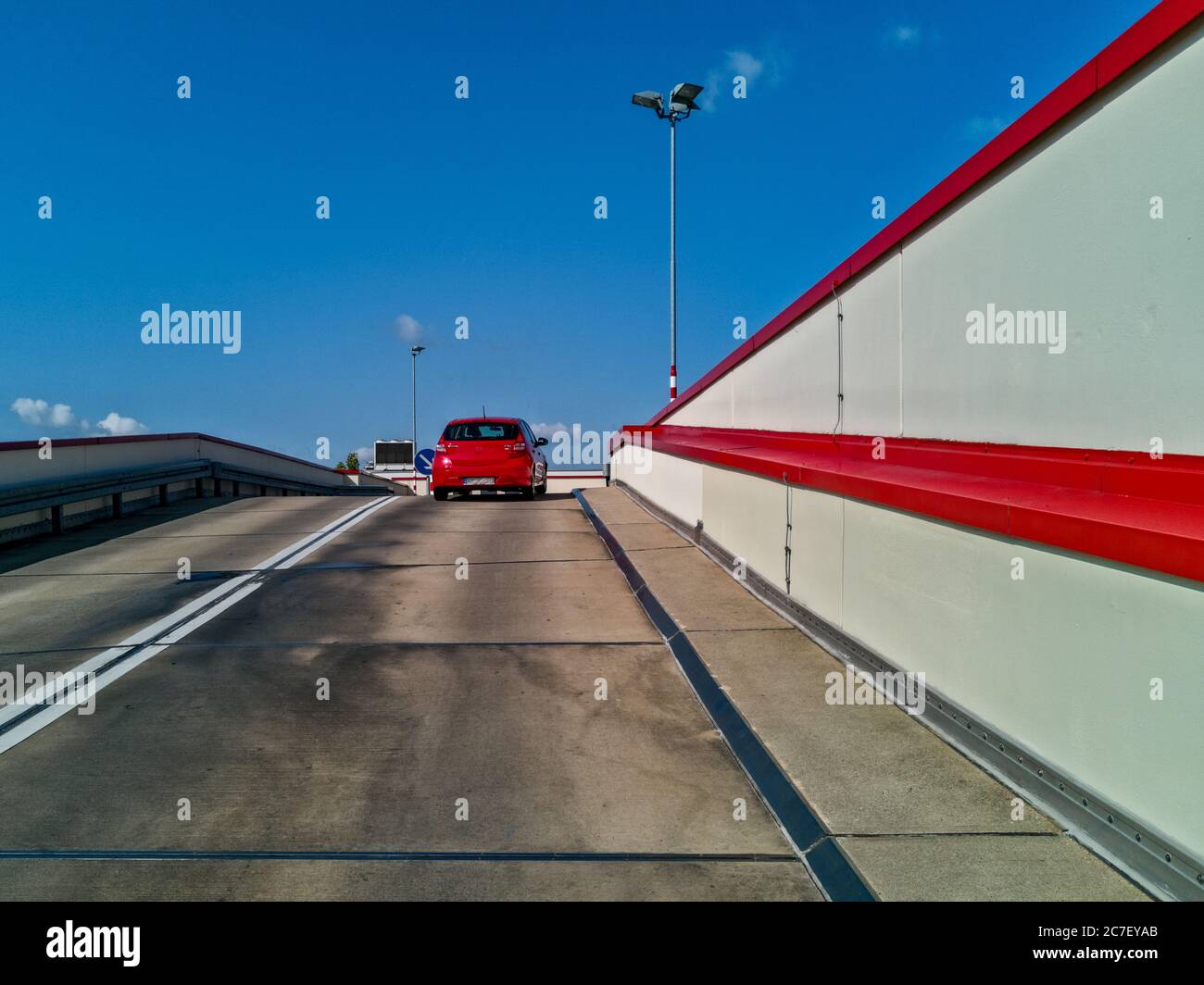 Horizontal shot of a red car in the movement on the highway under the ...
