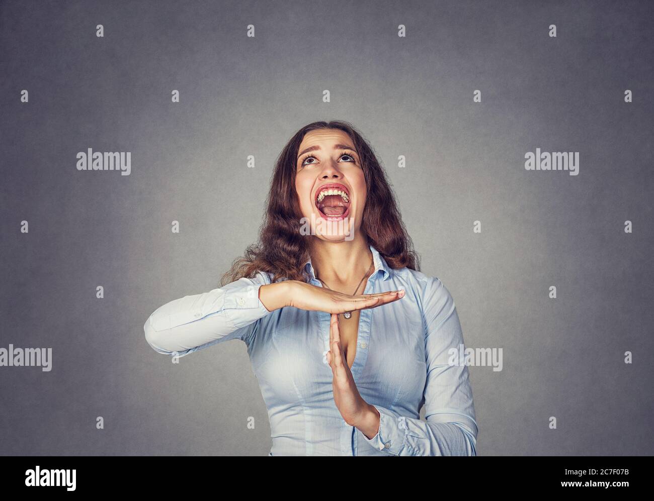 Young woman showing time out hand gesture, frustrated screaming to stop ...