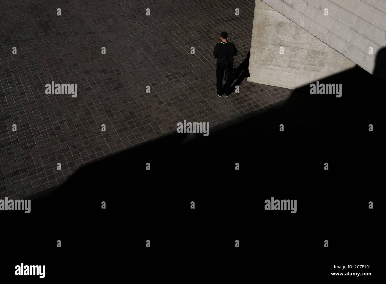 High angle shot of a male near a white building during daytime Stock ...