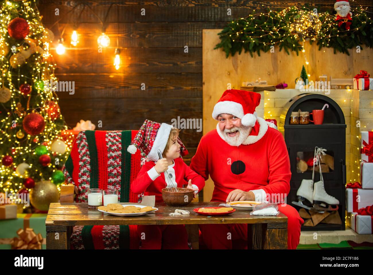 Santa helper. Cute little child boy and daddy make gingerbread cookies ...