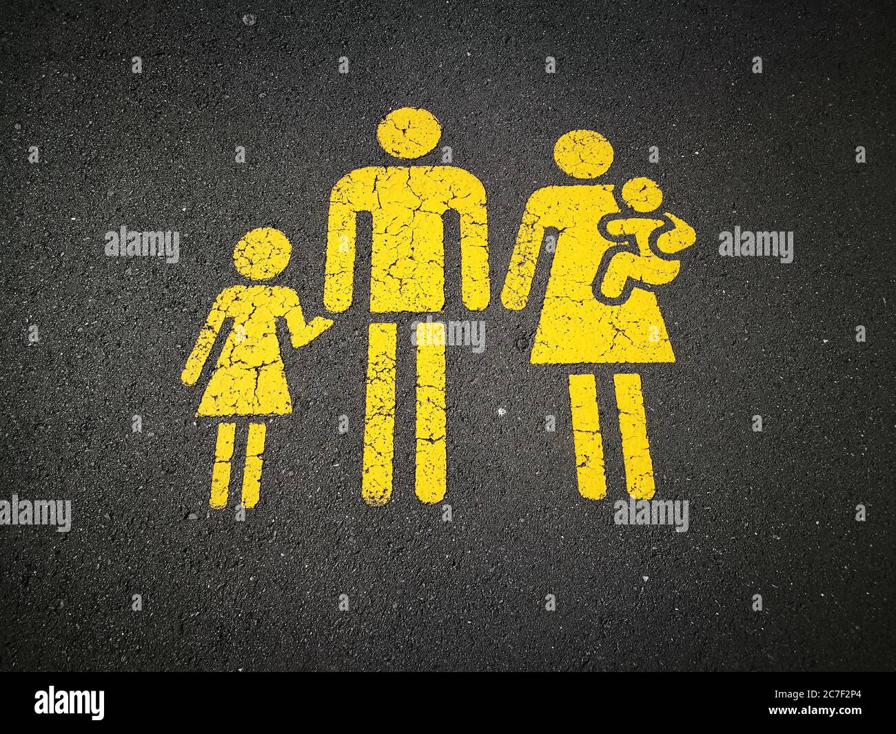 Horizontal shot of a yellow family parking sign on a grey surface Stock ...