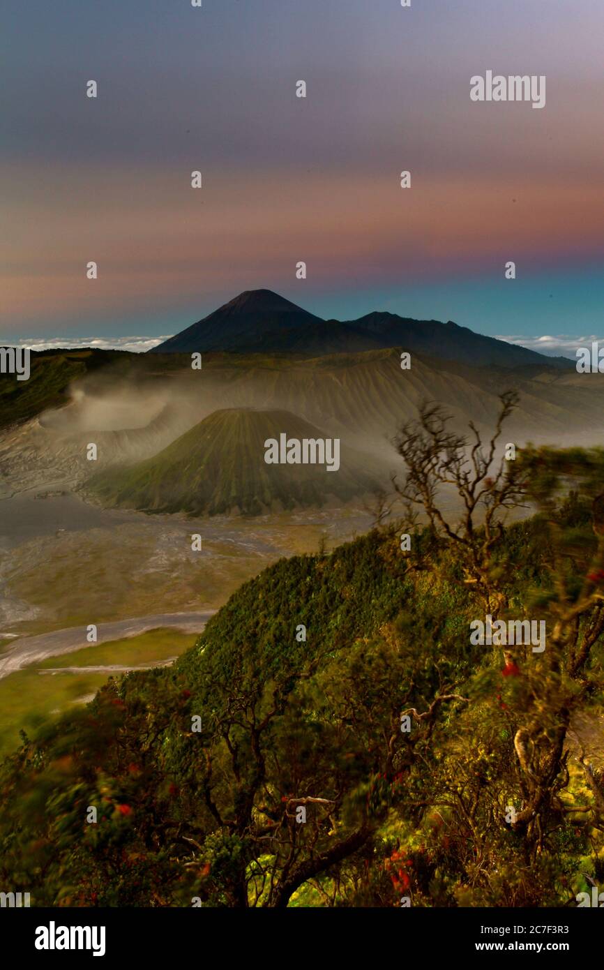 Vertical shot of beautiful green mountains and Bromo volcano in ...