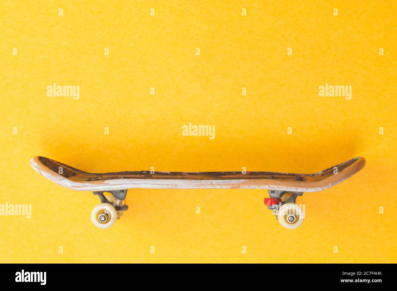Small skateboard on yellow background. tiny skate for fingers ...