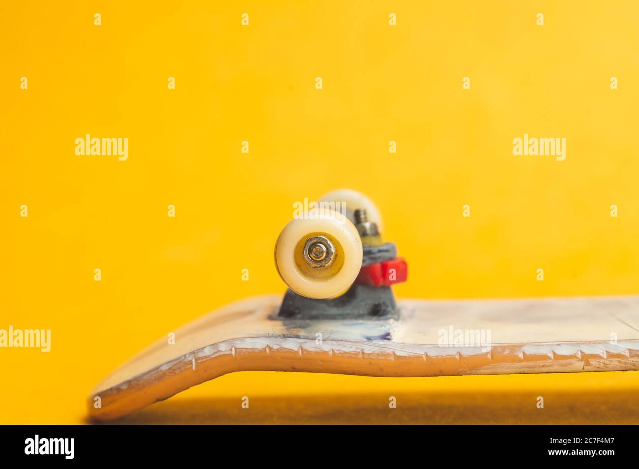 Small skateboard on yellow background. tiny skate for fingers ...