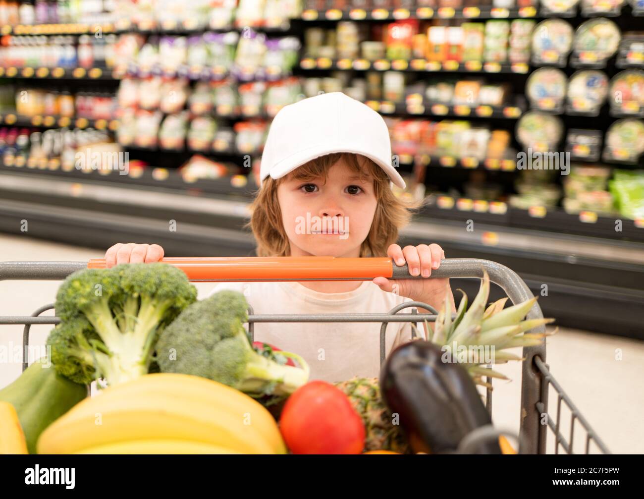A boy is shopping in a supermarket. Funny customer boy child holdind ...