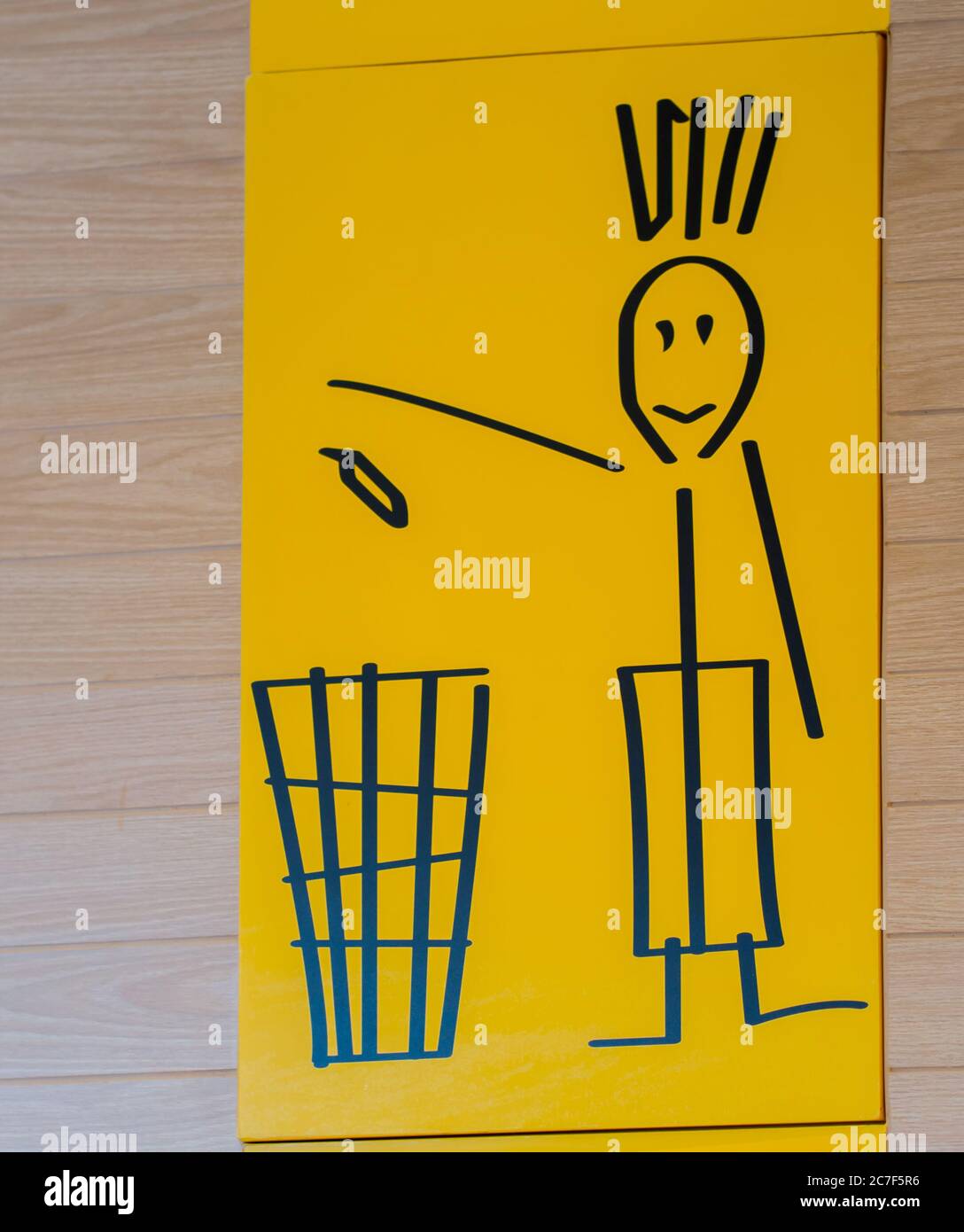 trash bin sign on the wall, yellow background Stock Photo - Alamy