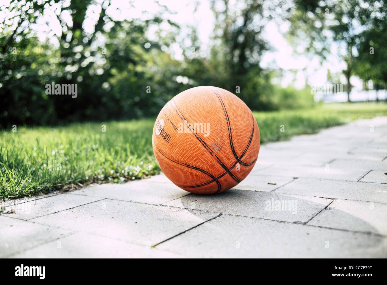 Beautiful view of a basketball on the pavement by the grass Stock Photo ...