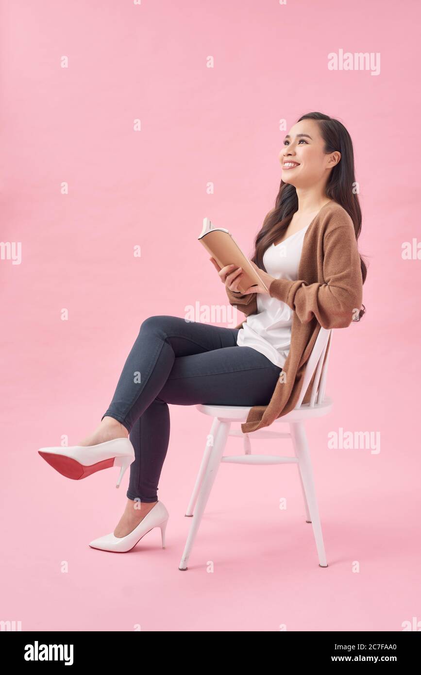 Asian female Reading Book on Chair, Full Body Isolated on pink Stock ...