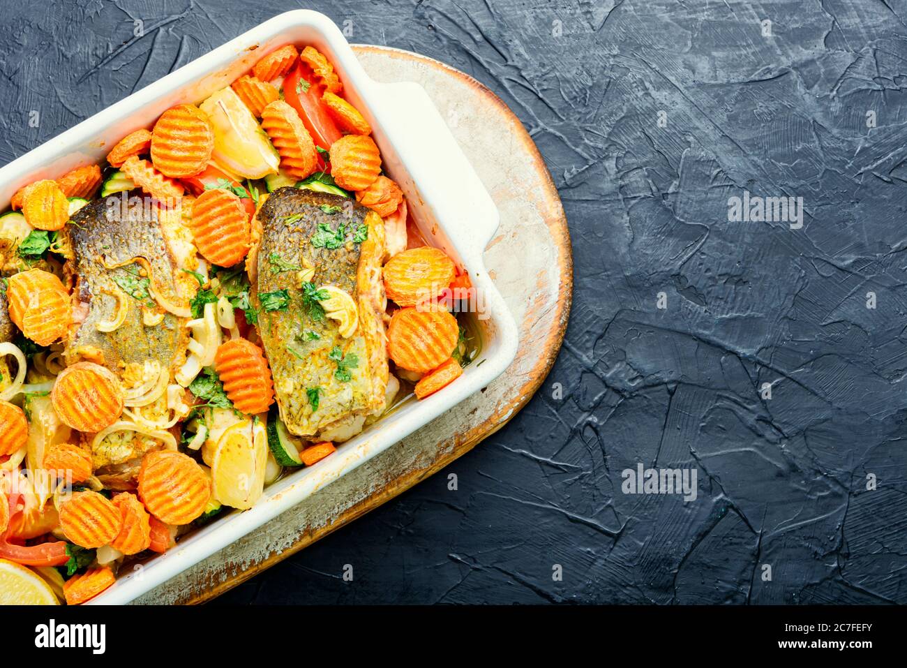 Baked fish steaks with grilled vegetables in baking dish.Delicious ...