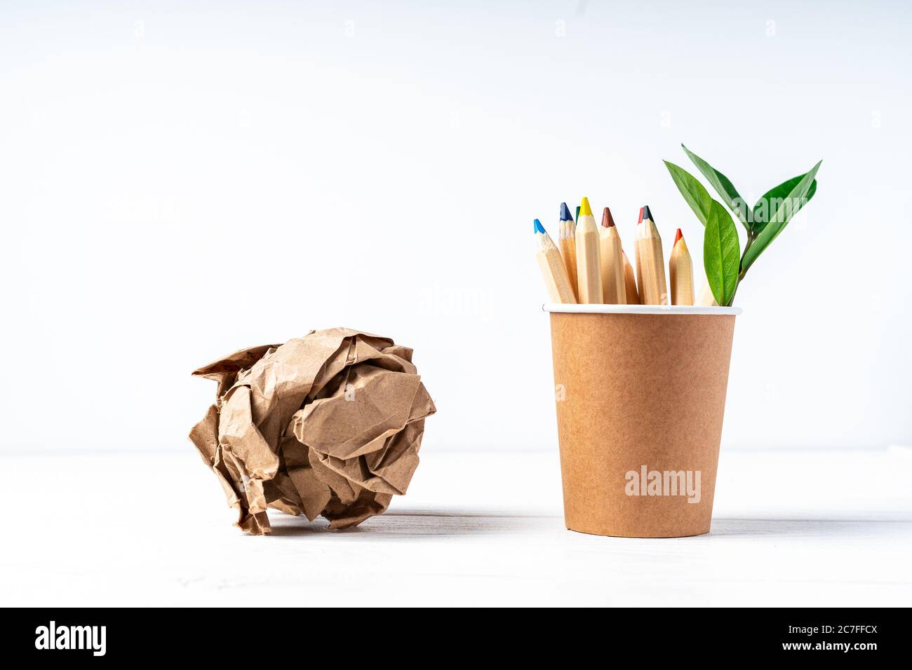 Craft paper coffee cup, pencils, green leaves sprout and recycled ...