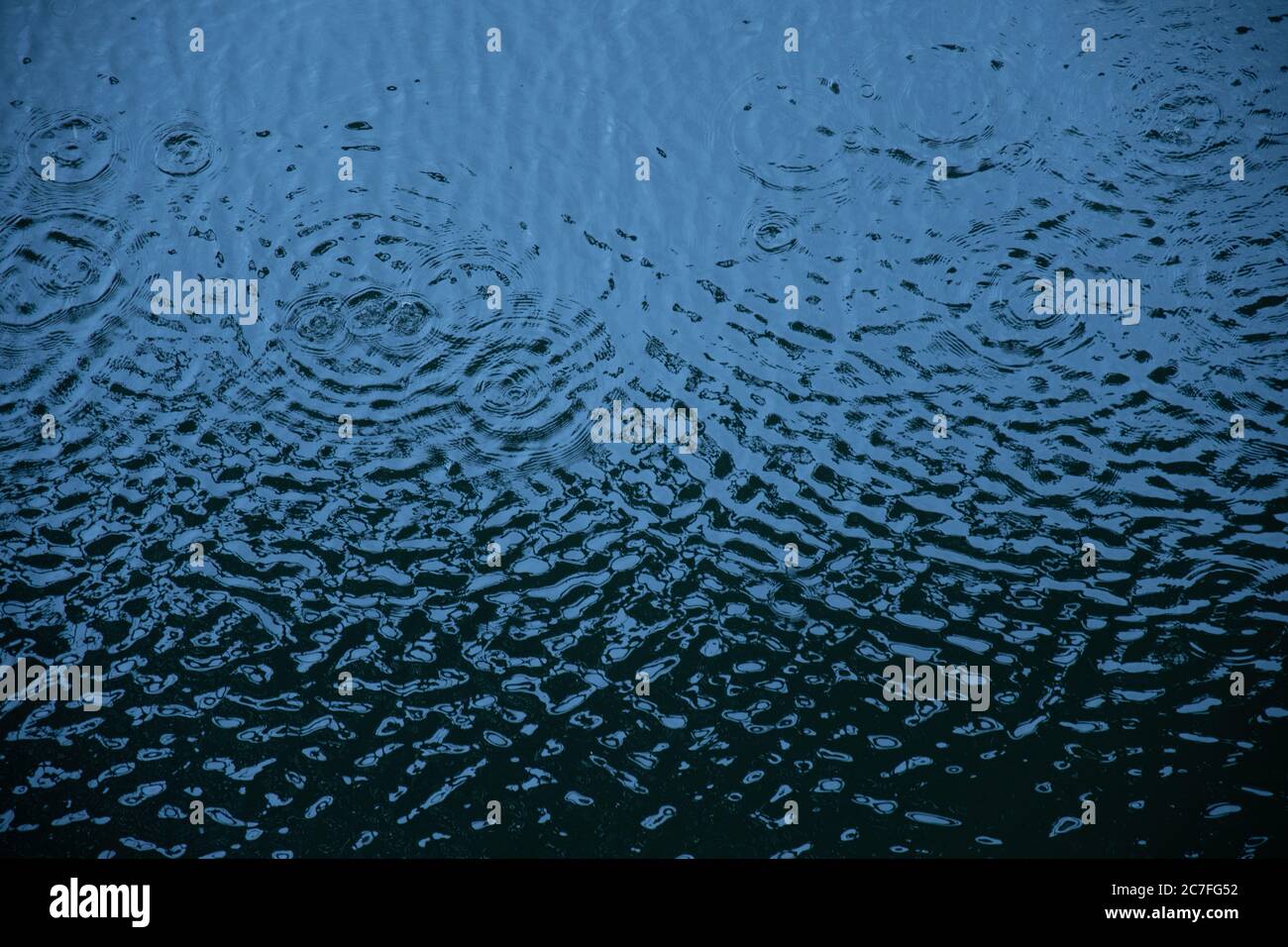 Ripple blue water surface with concentric pattern waves and copy space ...