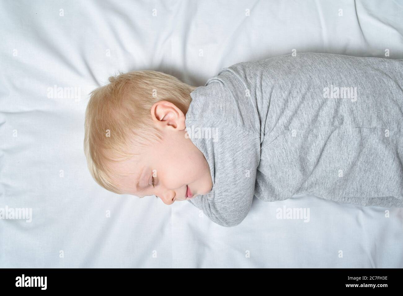 Cute blond boy sleeping with his hand under his head. White background ...
