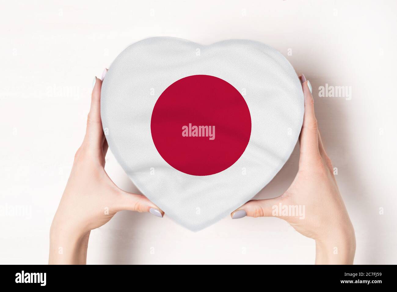 Flag of Japan on a heart shaped box in a female hands. White background ...