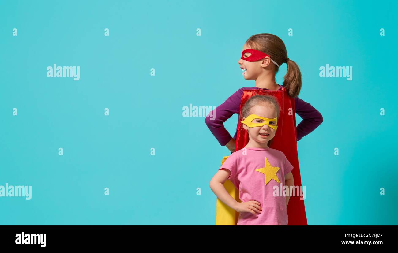 Little children are playing superhero. Kids on the background of bright ...