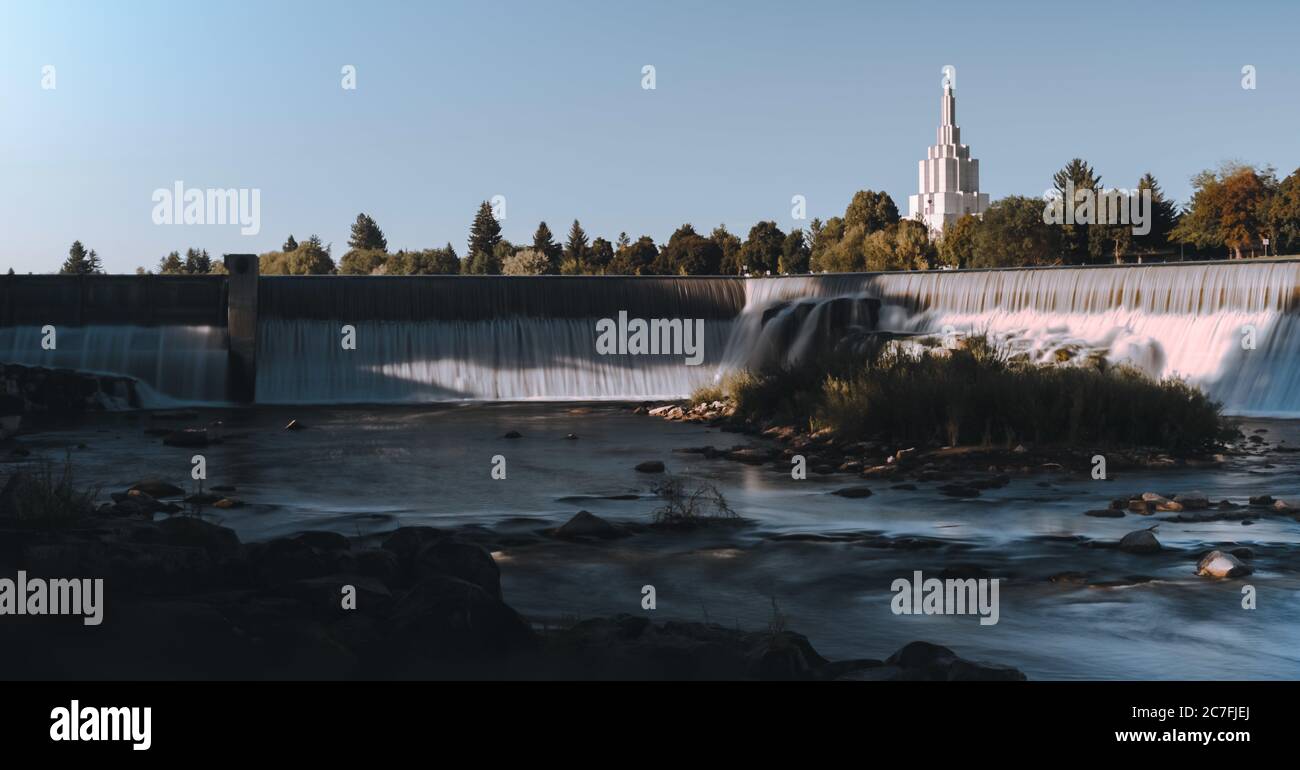 Scenery of a strong waterfall flowing into the river in the middle of ...