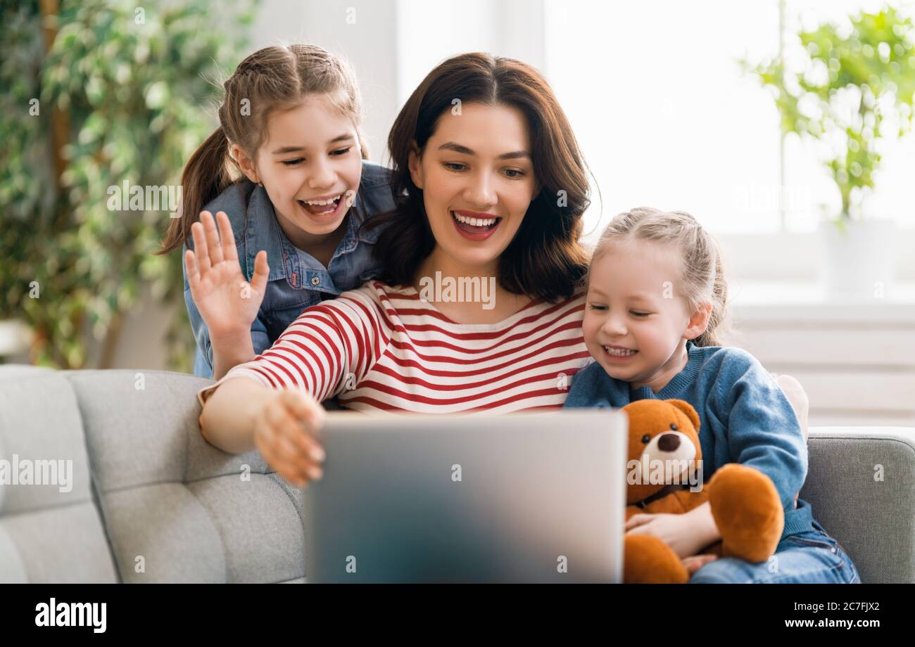 Happy loving family. Young mother and daughters girls using laptop ...