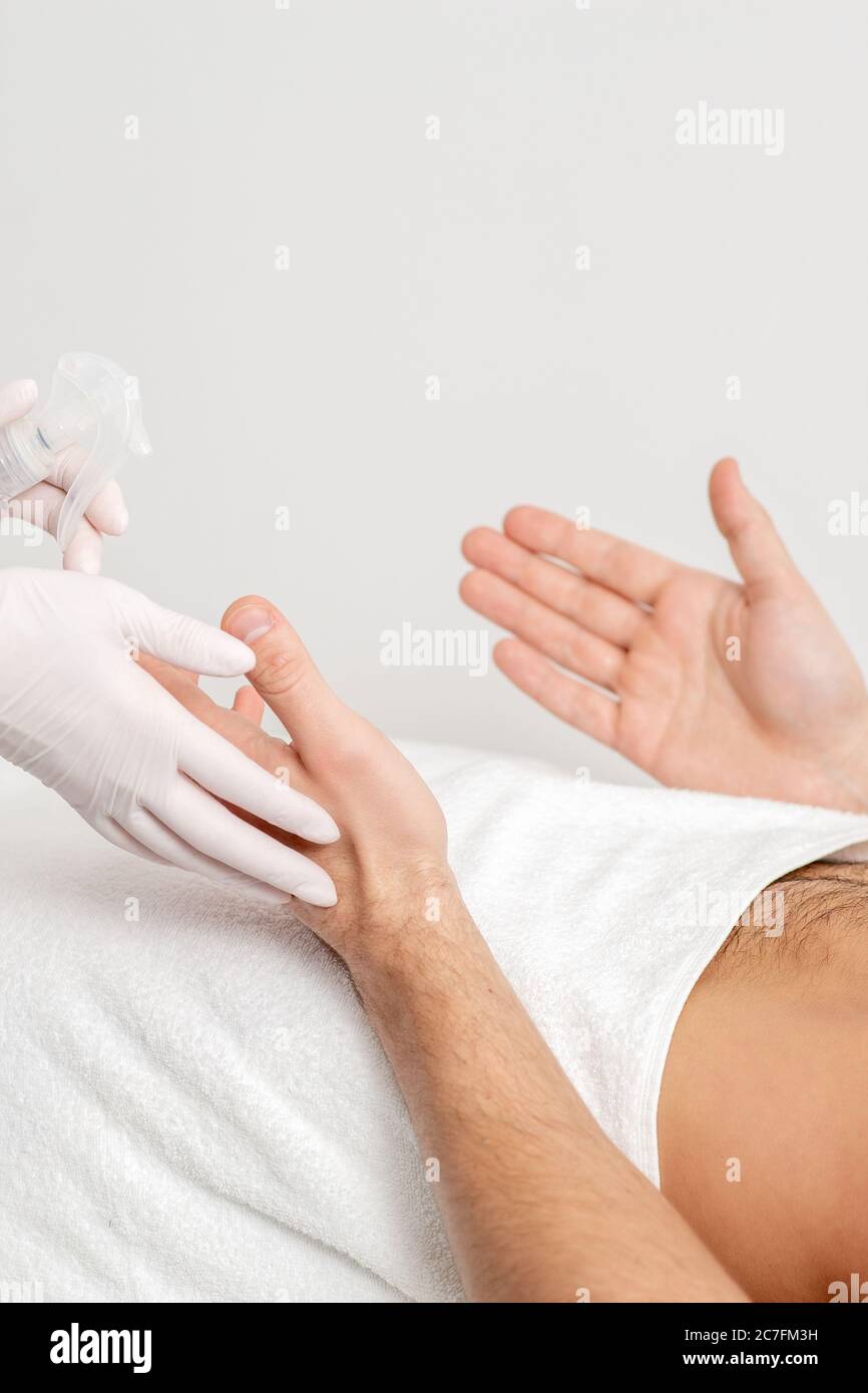Nurse hand sanitizing hands of male patient in the hospital ...