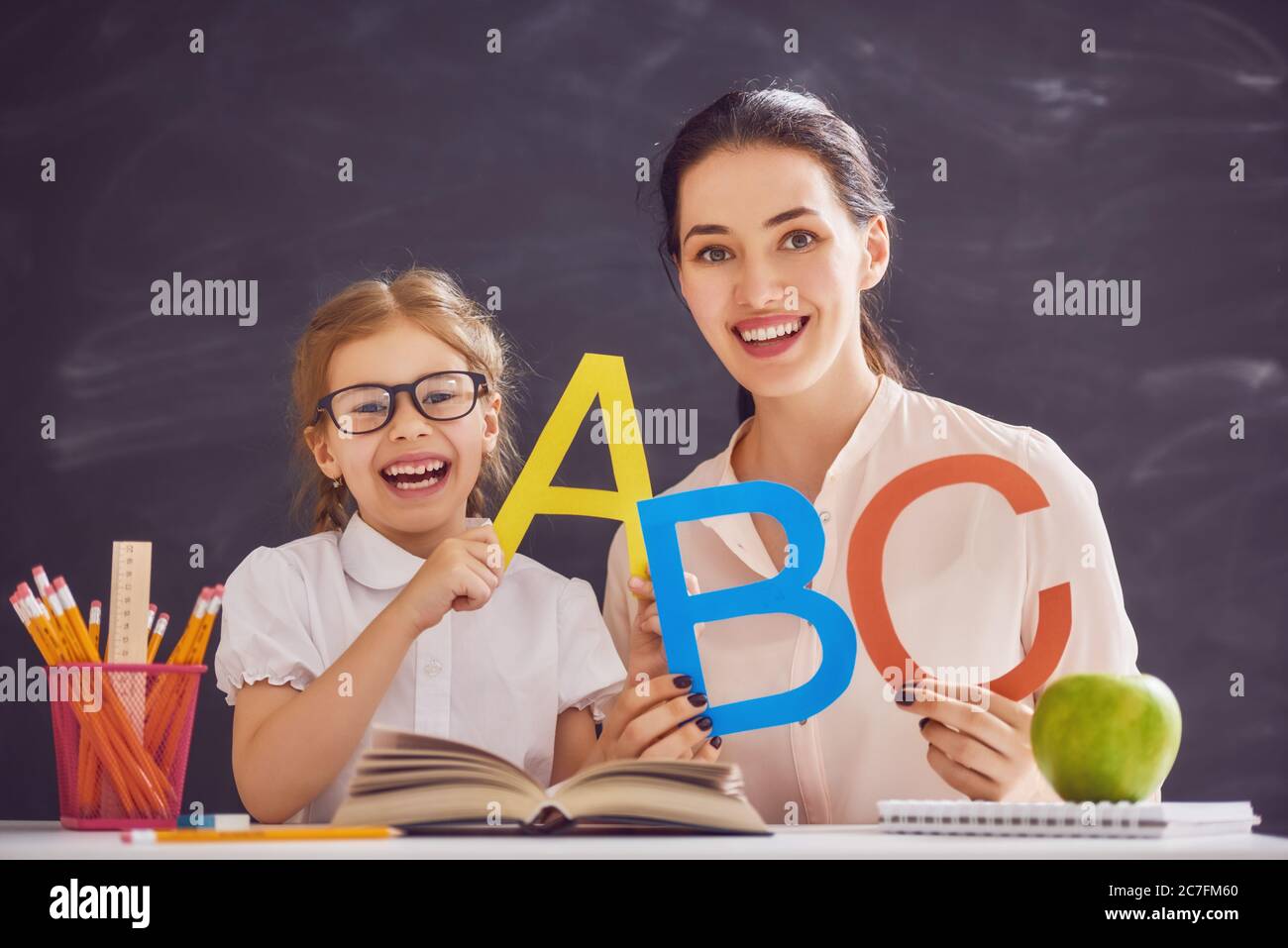 Back to school! Child is learning to write. Adult woman teaches child ...