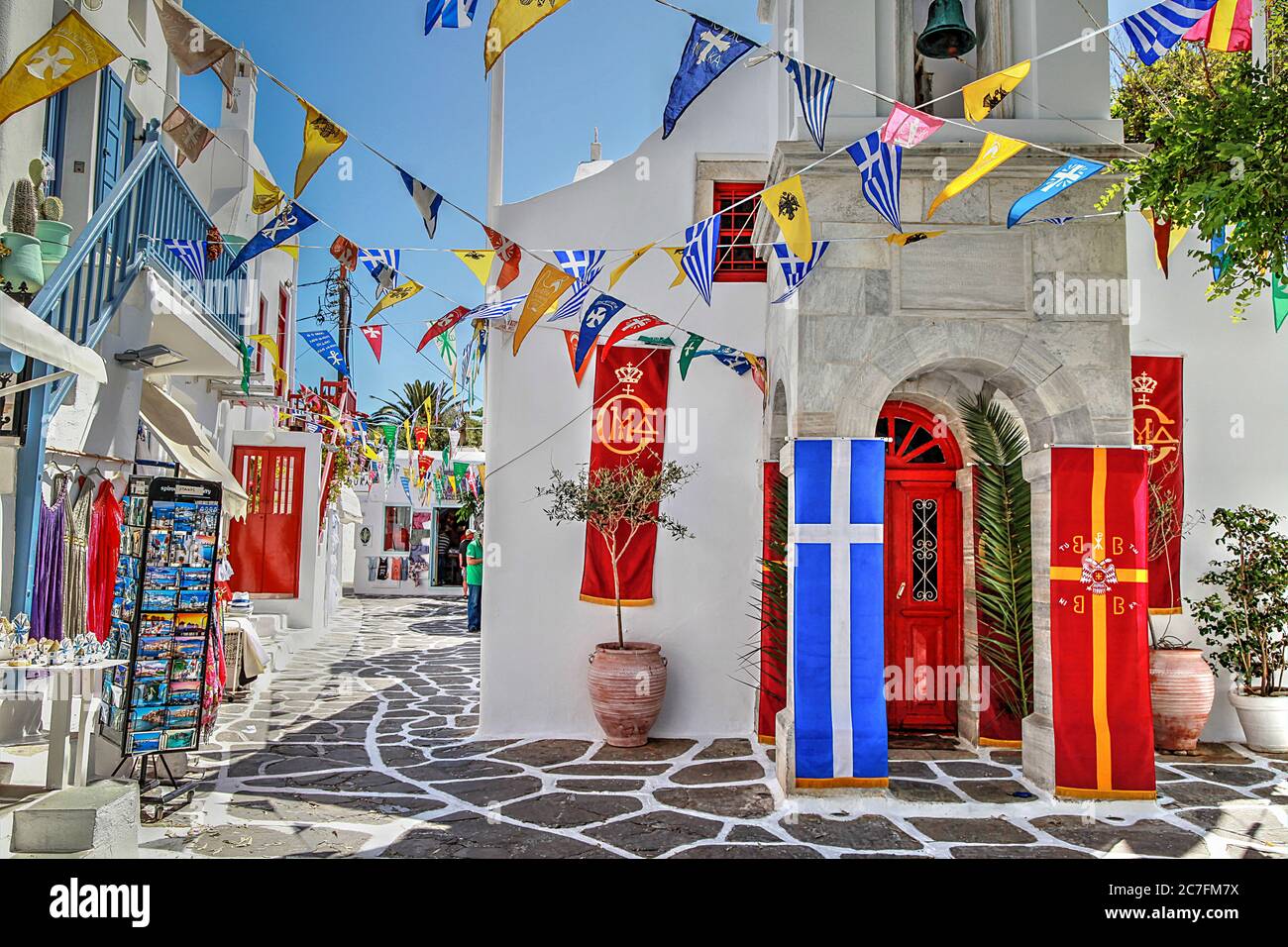 Mykonos, Greece - July 6, 2017: Festoons and flags. over a little ...